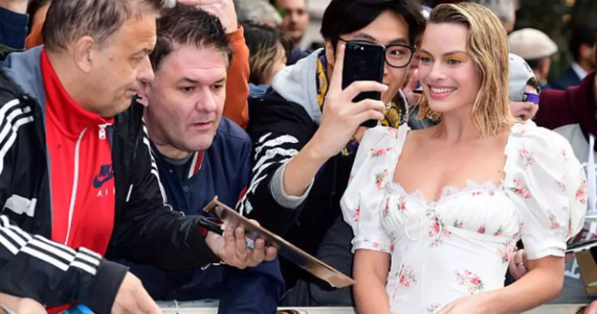 Margot Robbie iwwerrascht an engem Mëssgléckt Wee op engem rouden Teppech